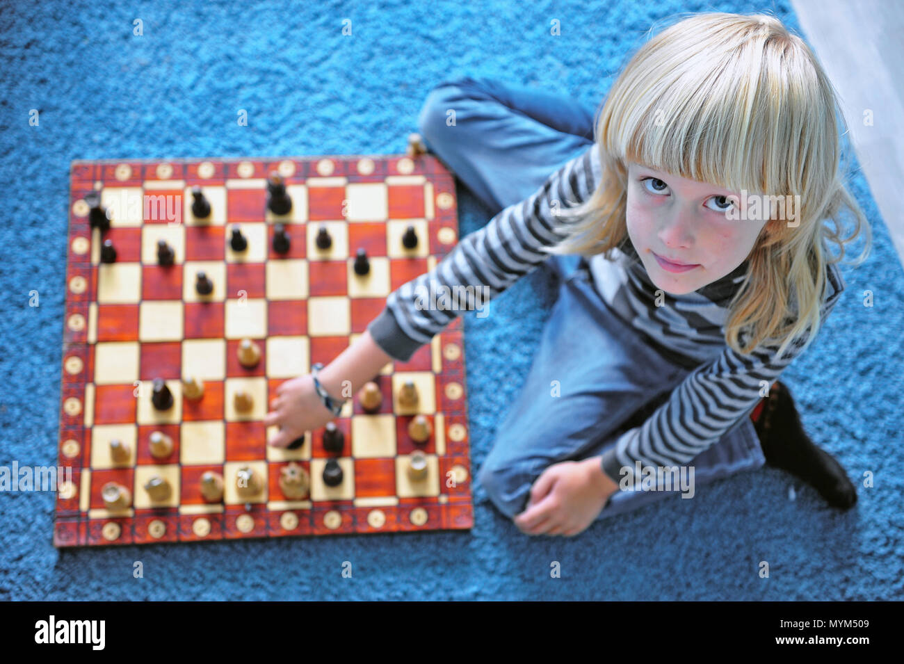 Little kid training chess on carpet Stock Photo - Alamy