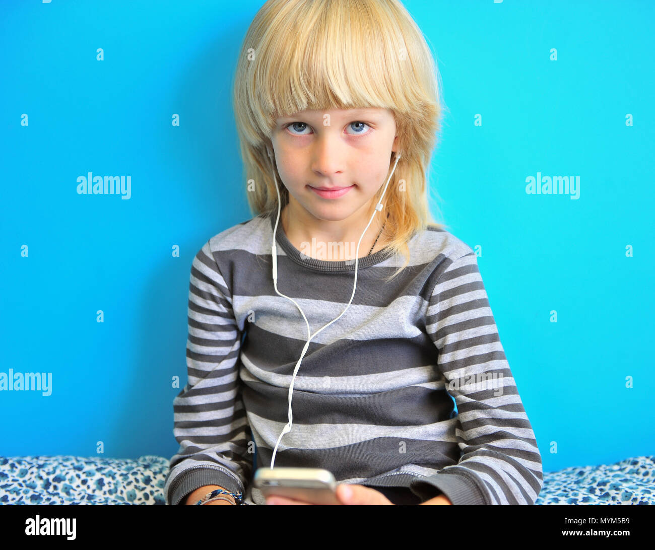 Little kid listening music using smartphone Stock Photo - Alamy