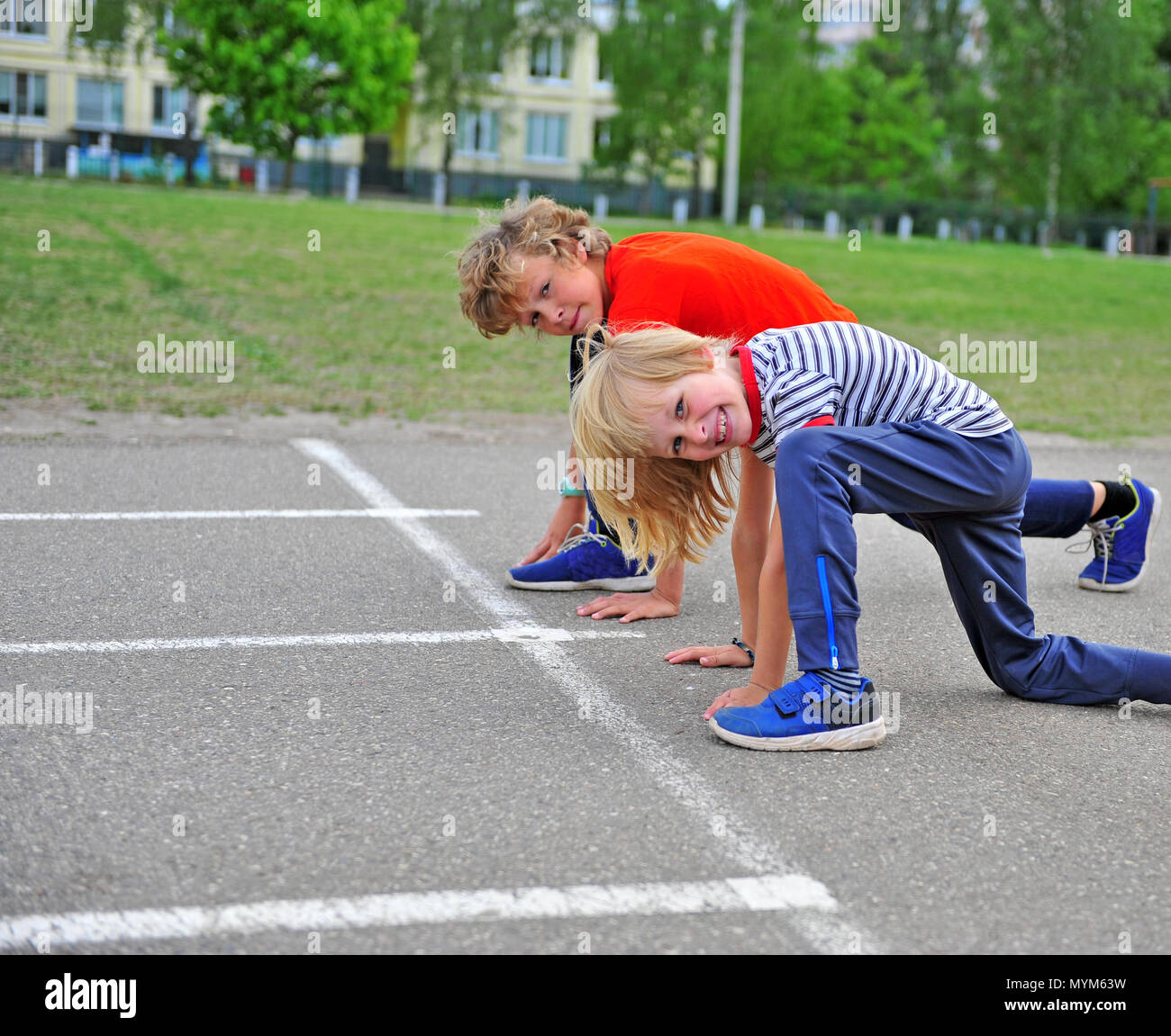 Two kids ready to run on the track Stock Photo - Alamy