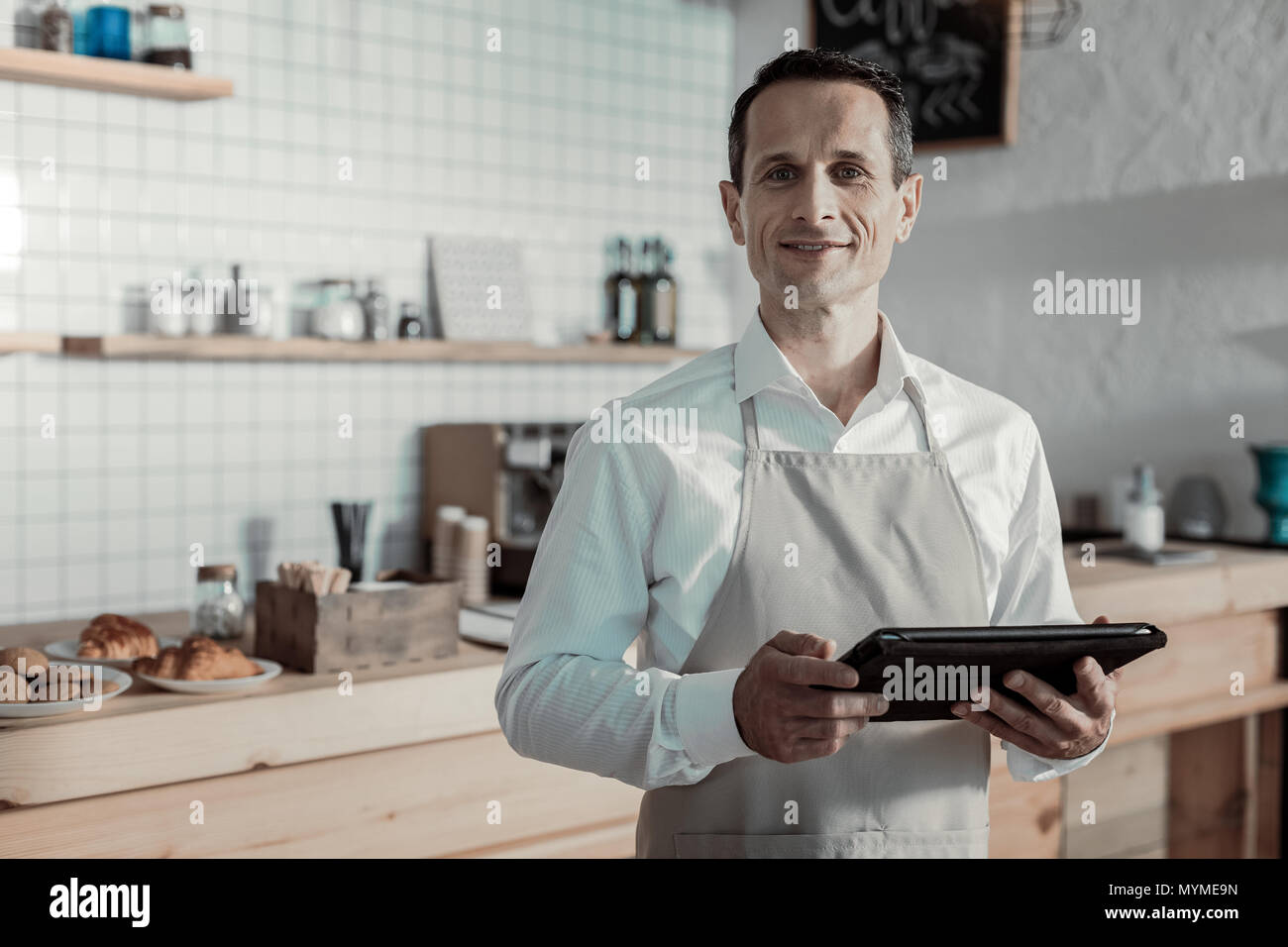 Positive delighted waiter looking at camera Stock Photo - Alamy