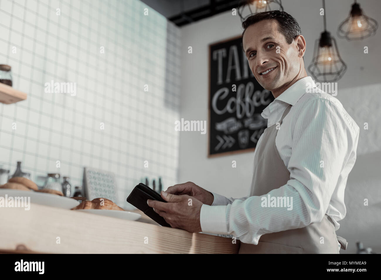 Joyful waiter standing in semi position Stock Photo - Alamy