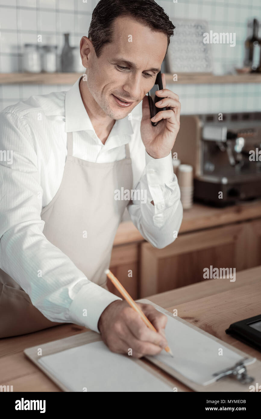 Cheerful waiter listening to his interlocutor Stock Photo - Alamy