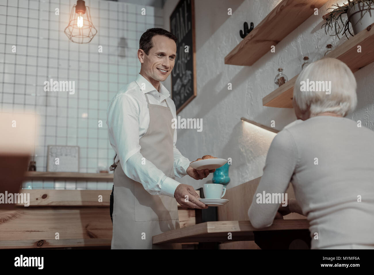 Attractive worker bringing coffee to his client Stock Photo - Alamy