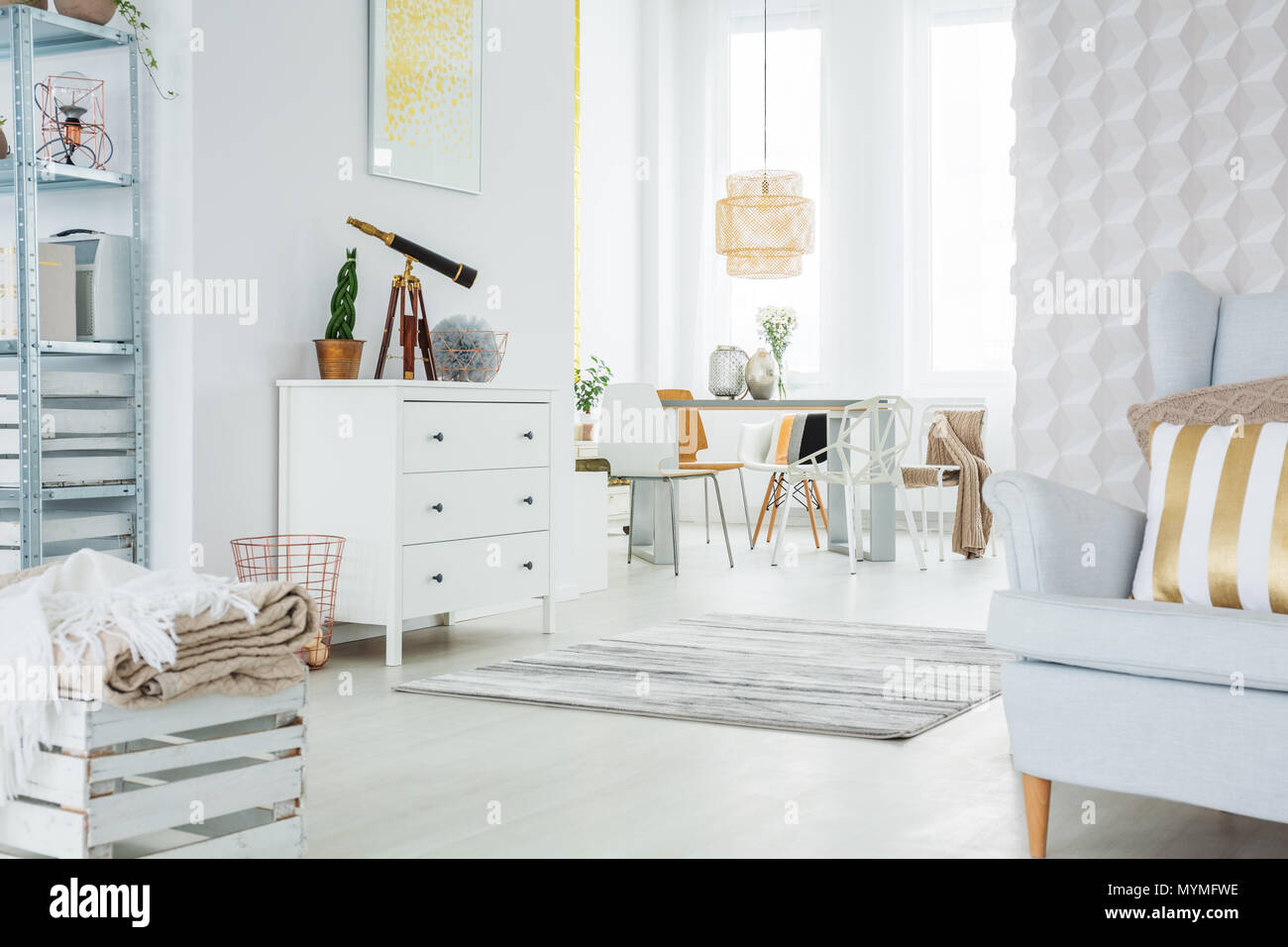 White, functional apartment with dresser, armchair and dining area ...