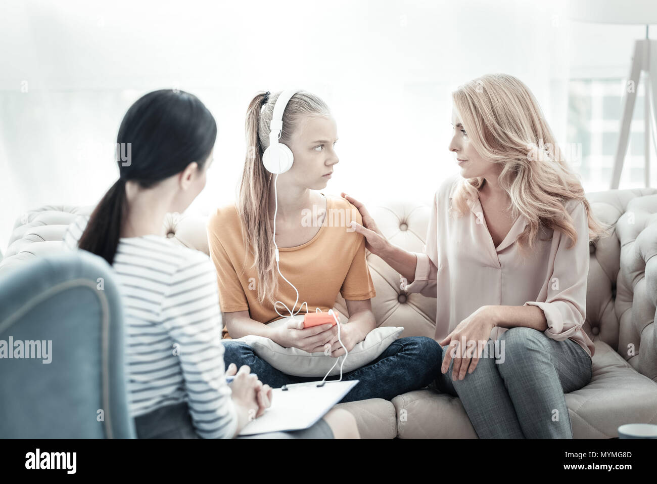 Concerned mom and daughter asking psychologist Stock Photo - Alamy