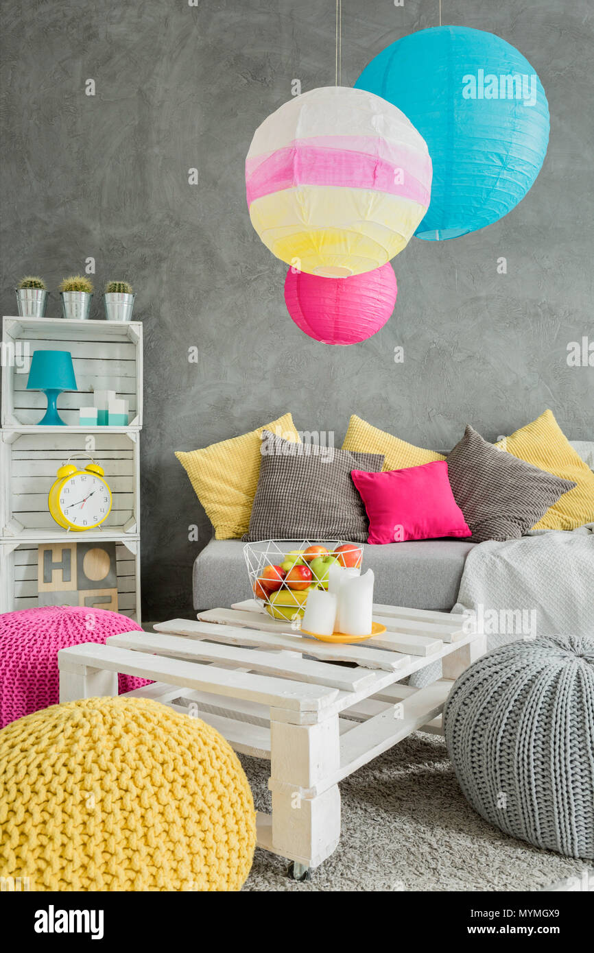 Image of a grey living room with colorful poufs, pillows and lamp ...