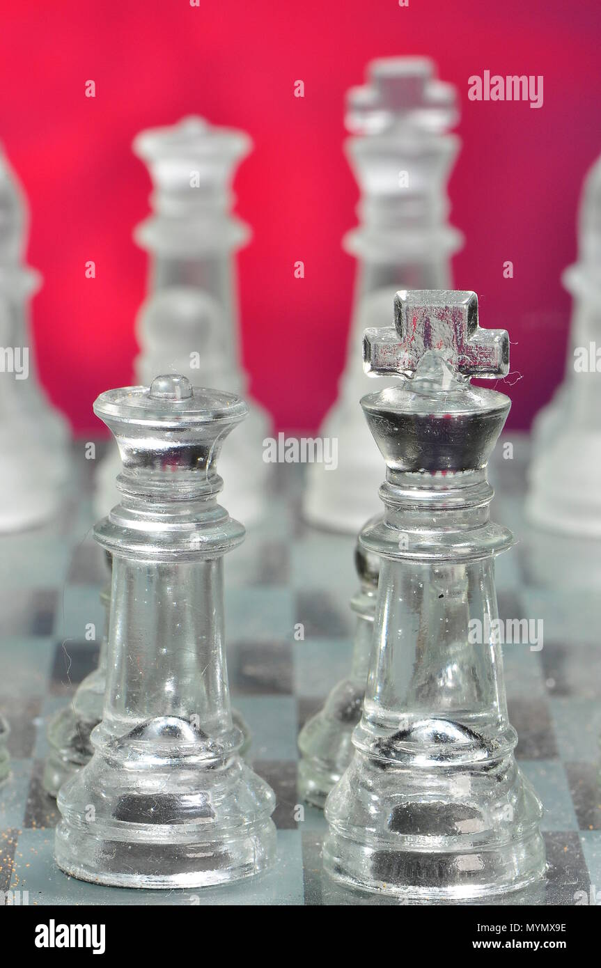 Glass chess pieces in a red background Stock Photo - Alamy