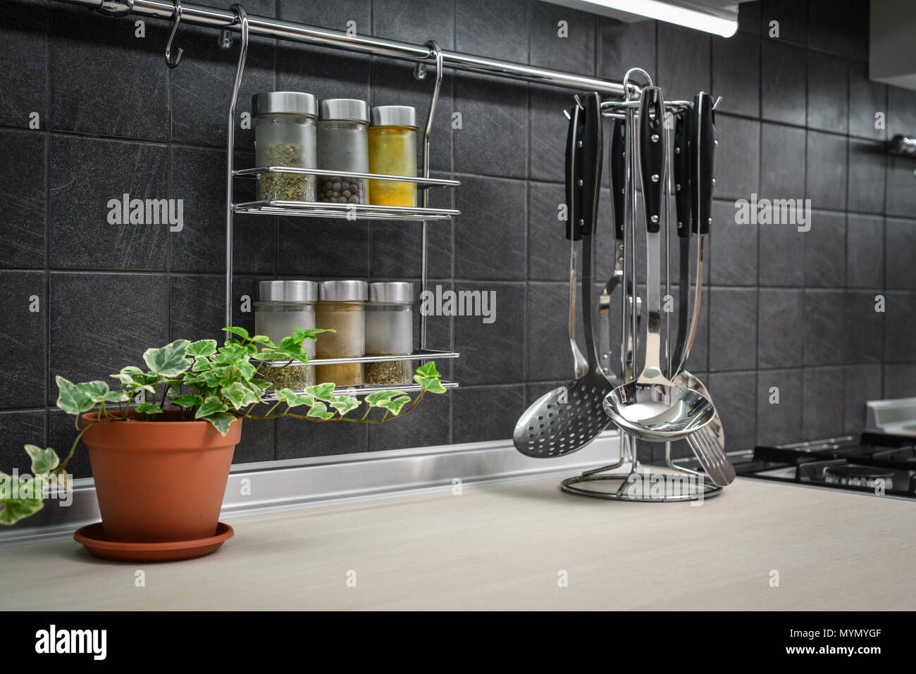 Jars of spices in hanging shelf in modern kitchen interior closeup ...