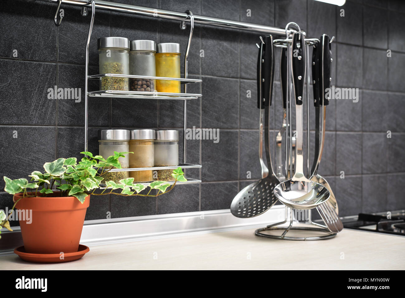 Jars of spices in hanging shelf in modern kitchen interior closeup ...