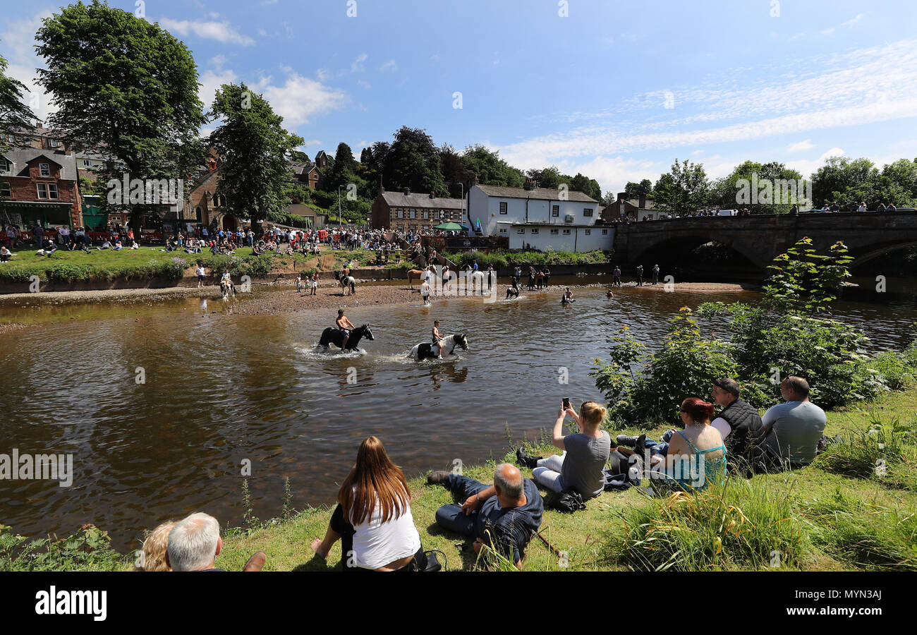 People riding horses in the river Eden during the Horse Fair in Appleby ...
