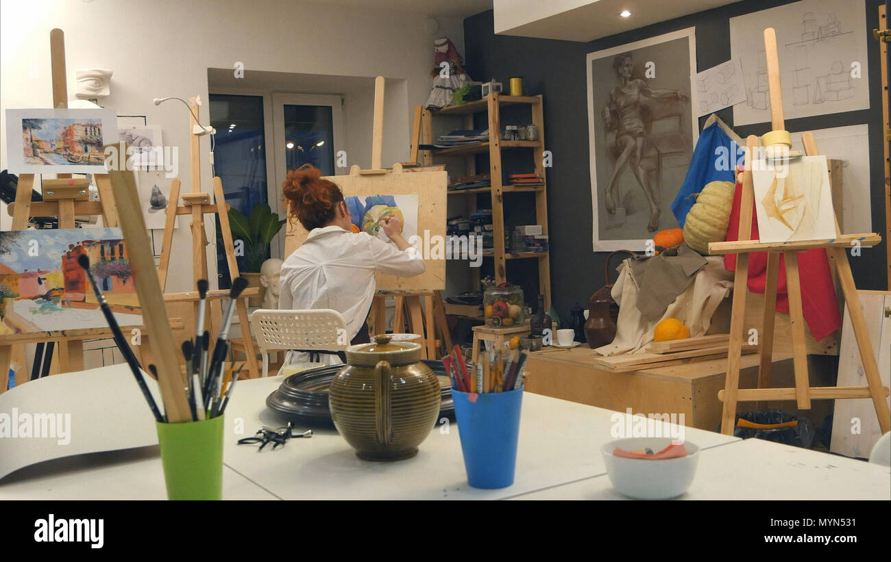 Ginger female artist painting still life in art studio Stock Photo - Alamy