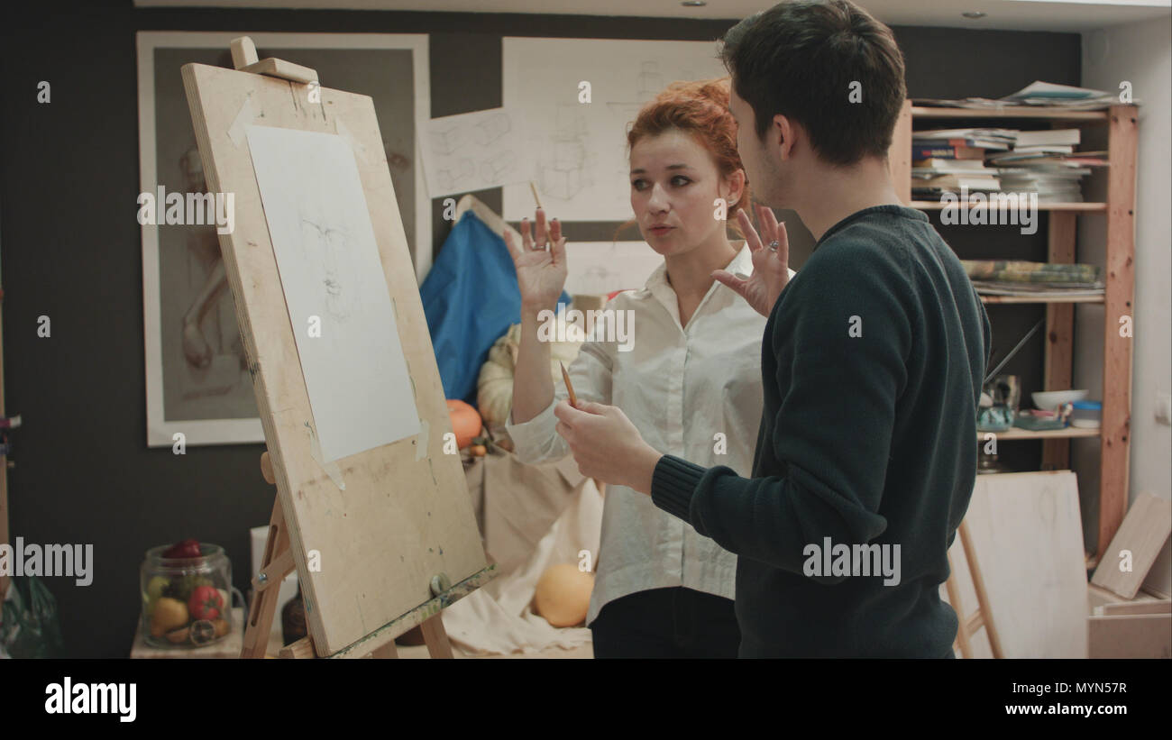 Student and art teacher during painting lesson Stock Photo - Alamy