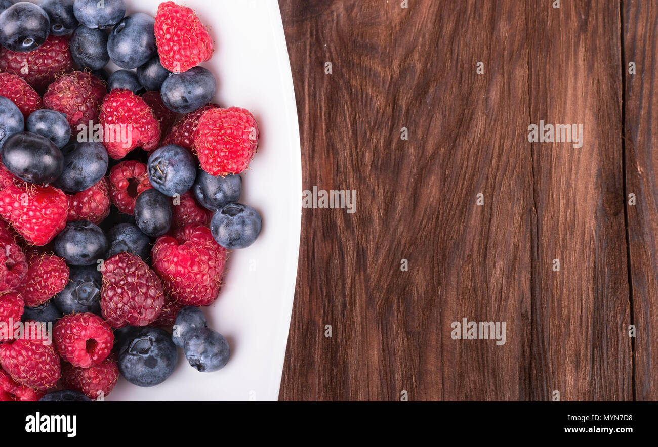Part plates blueberry and raspberry filling on a brown wooden table ...