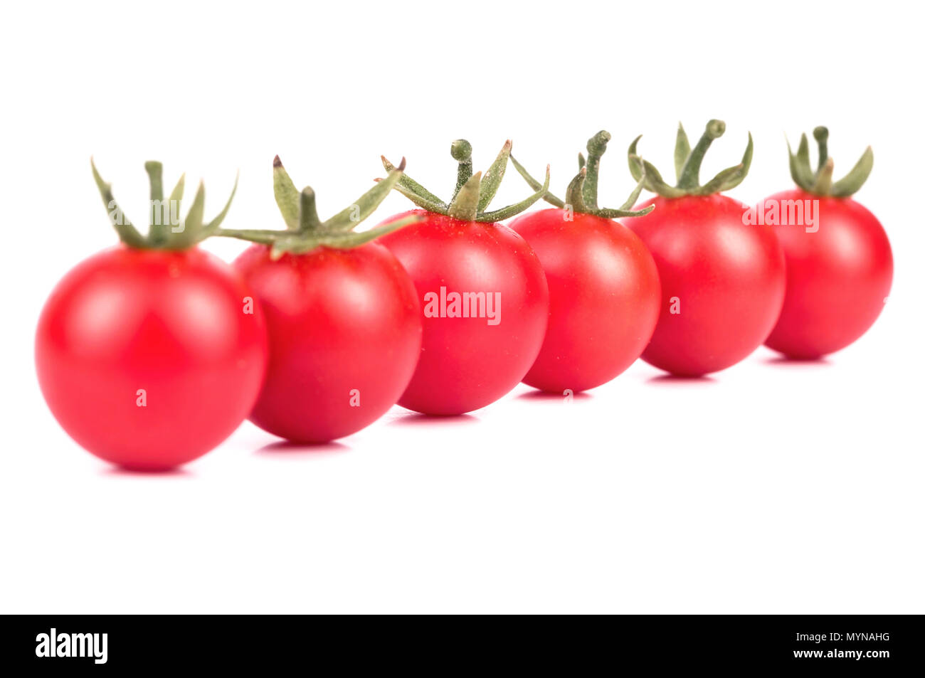 Six Little fresh cherry tomato constructed in a row on a white ...