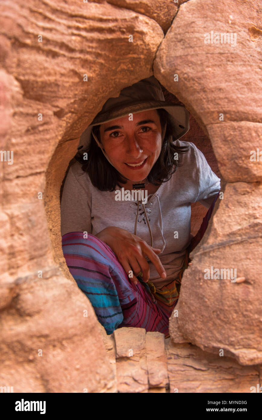 Portrait of a cute woman in a small hole in the rock Stock Photo - Alamy