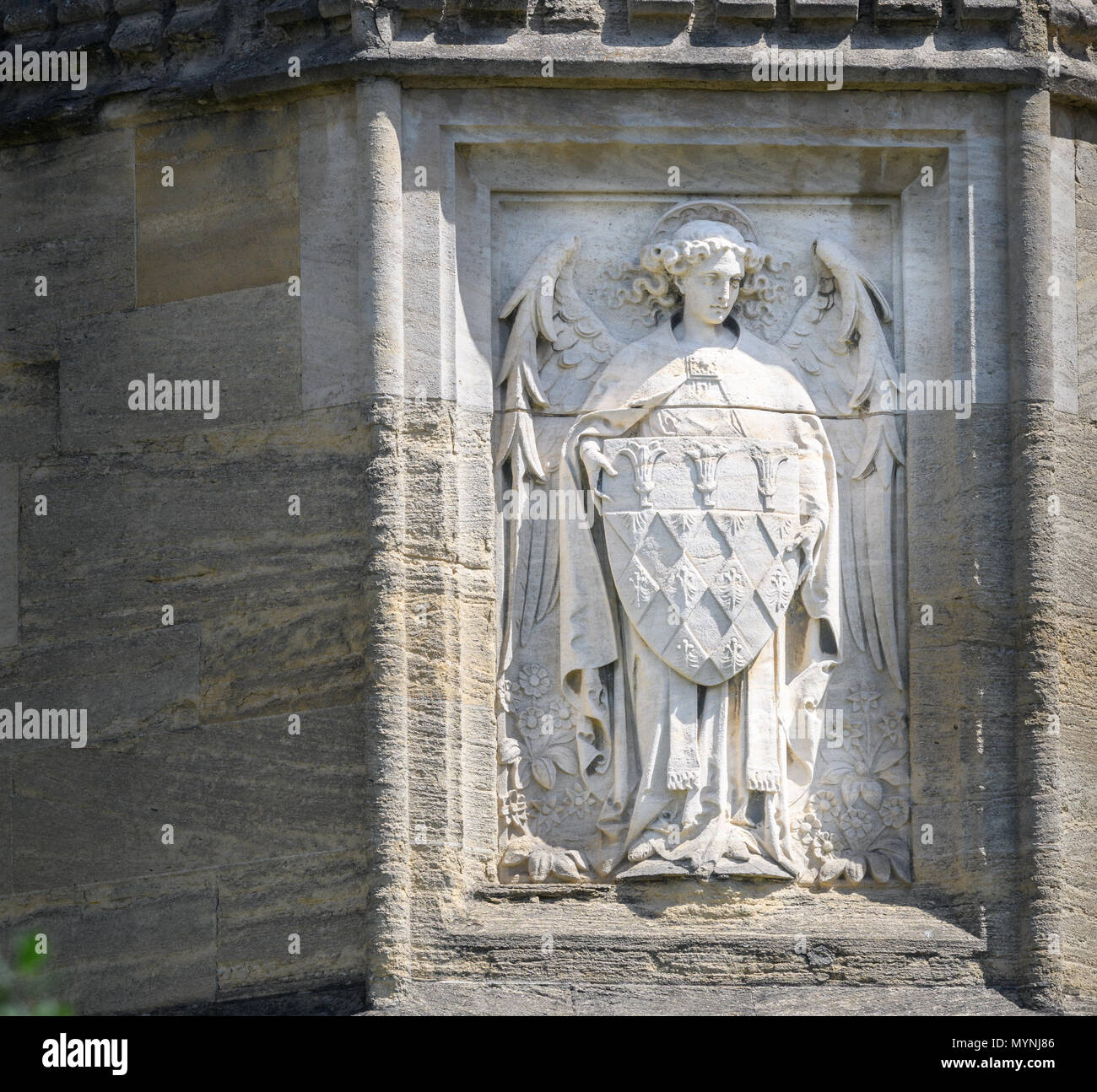 Stone carving (of an angel with a shield) on an outside wall at ...