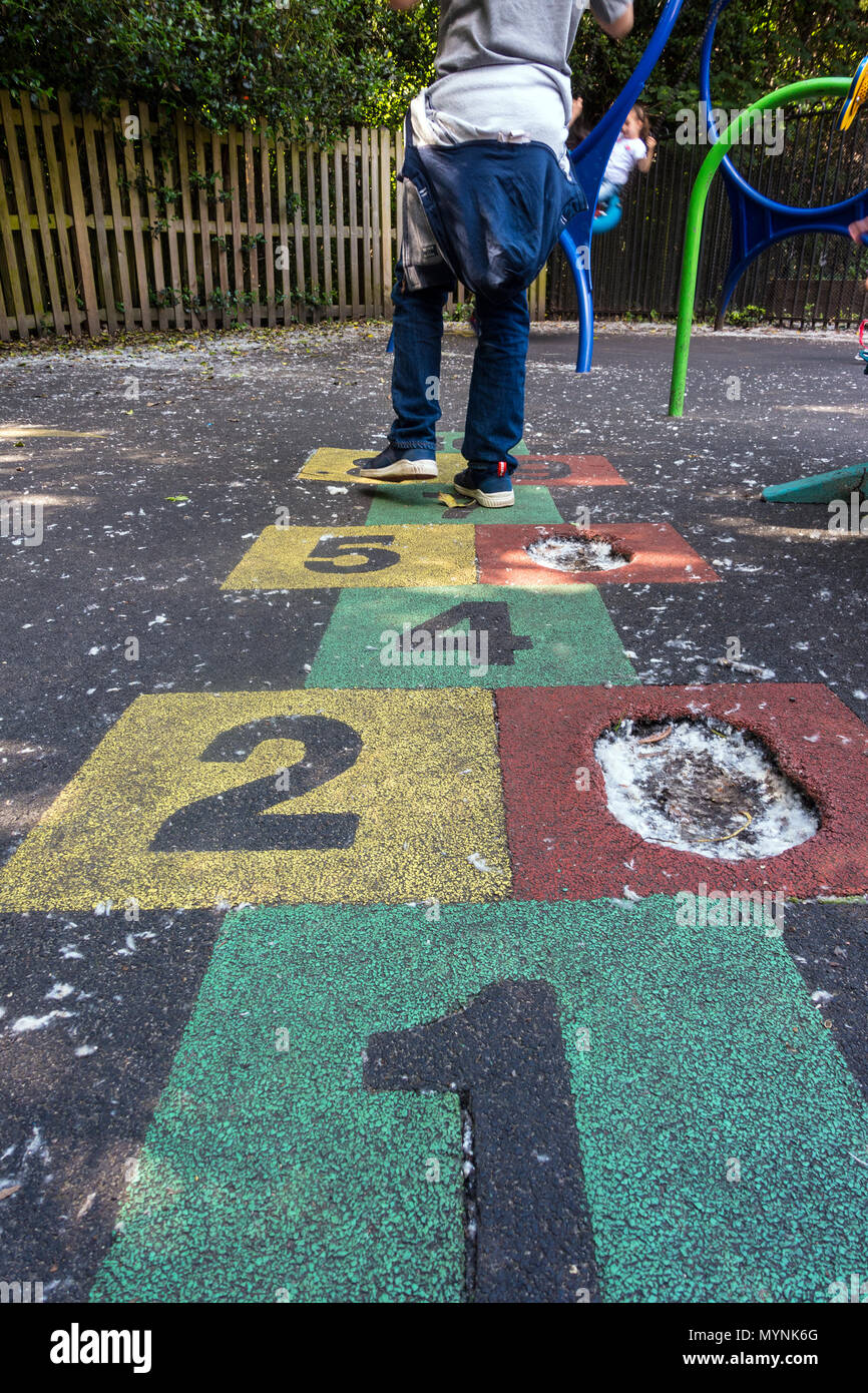 A child playing hopscotch in a children's playground Stock Photo - Alamy