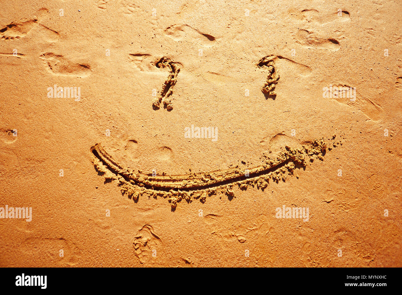 Smiley on the sand drawing by the sea Stock Photo - Alamy