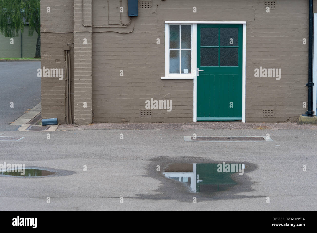 Green door and small window on a plain brick building at Duxford ...
