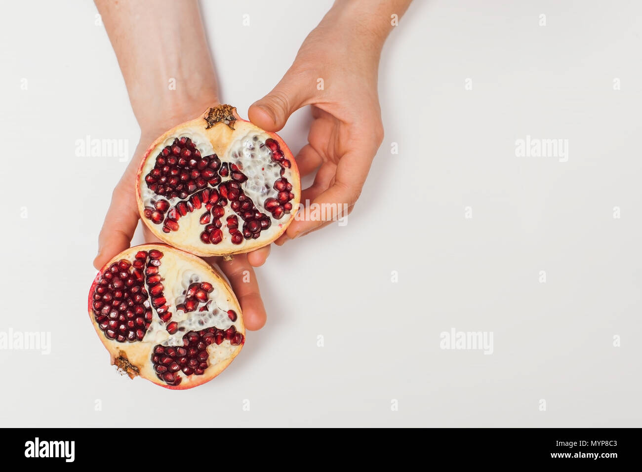 hand holding pomegranate isolated on white background Stock Photo - Alamy
