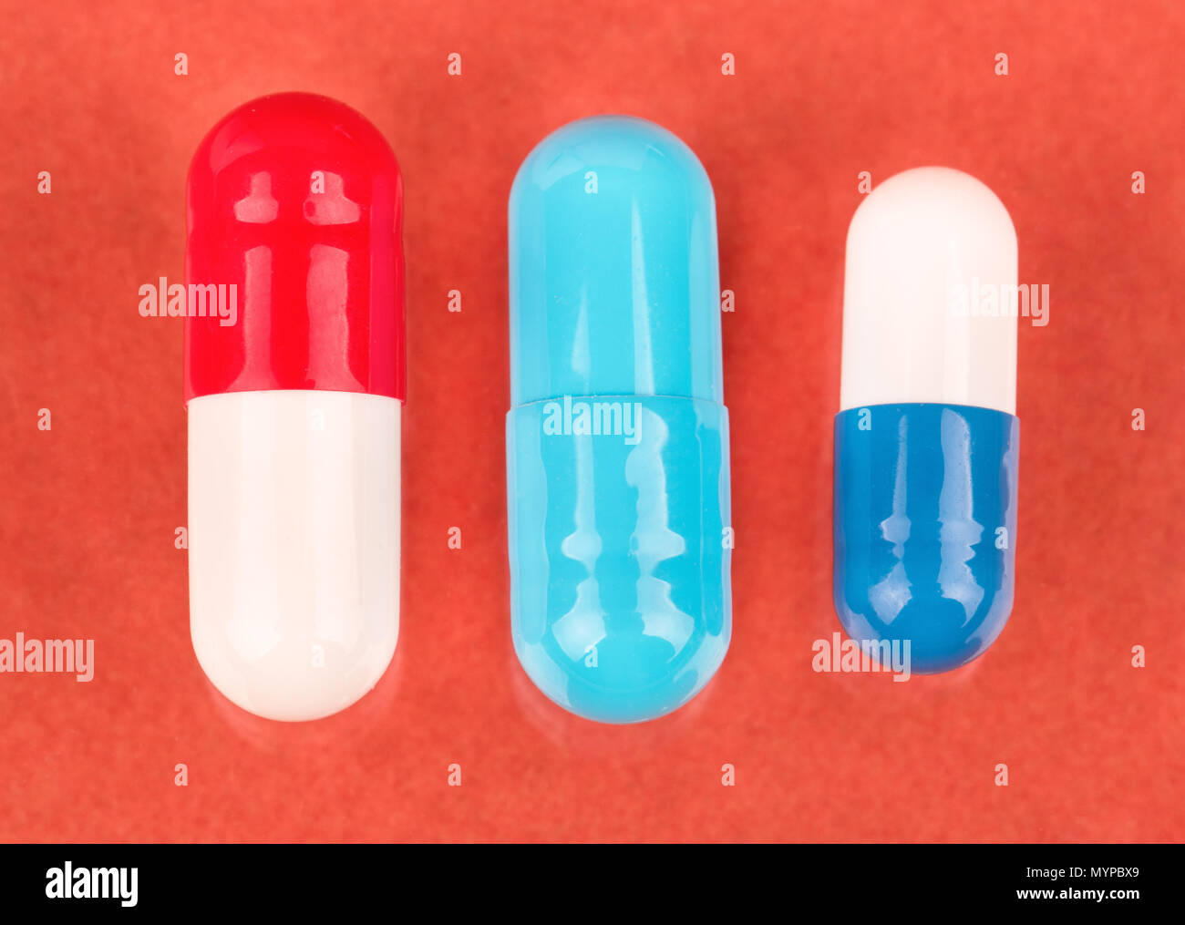 Three various color and shape capsules on a peachy background Stock ...