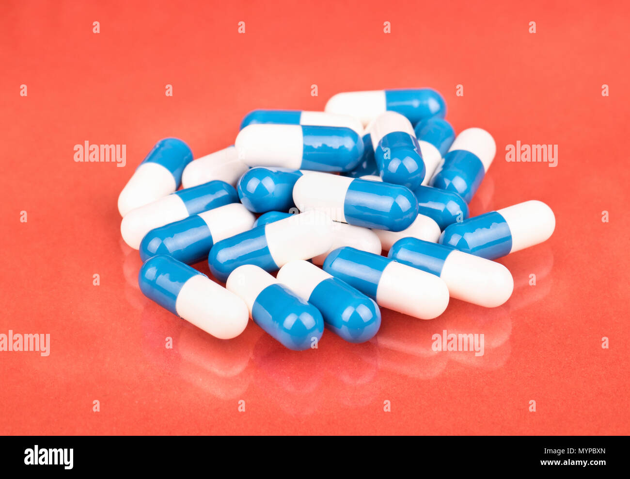Pile of little blue and white capsules on a peachy background Stock ...