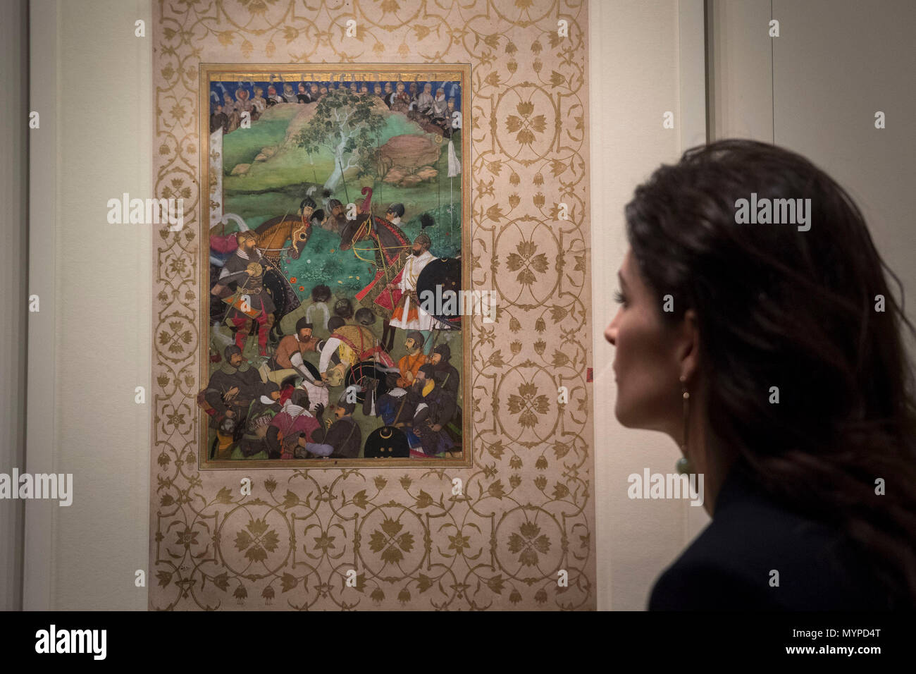 Curator Emily Hannam looks at a watercolour with gold paint, 'The ...