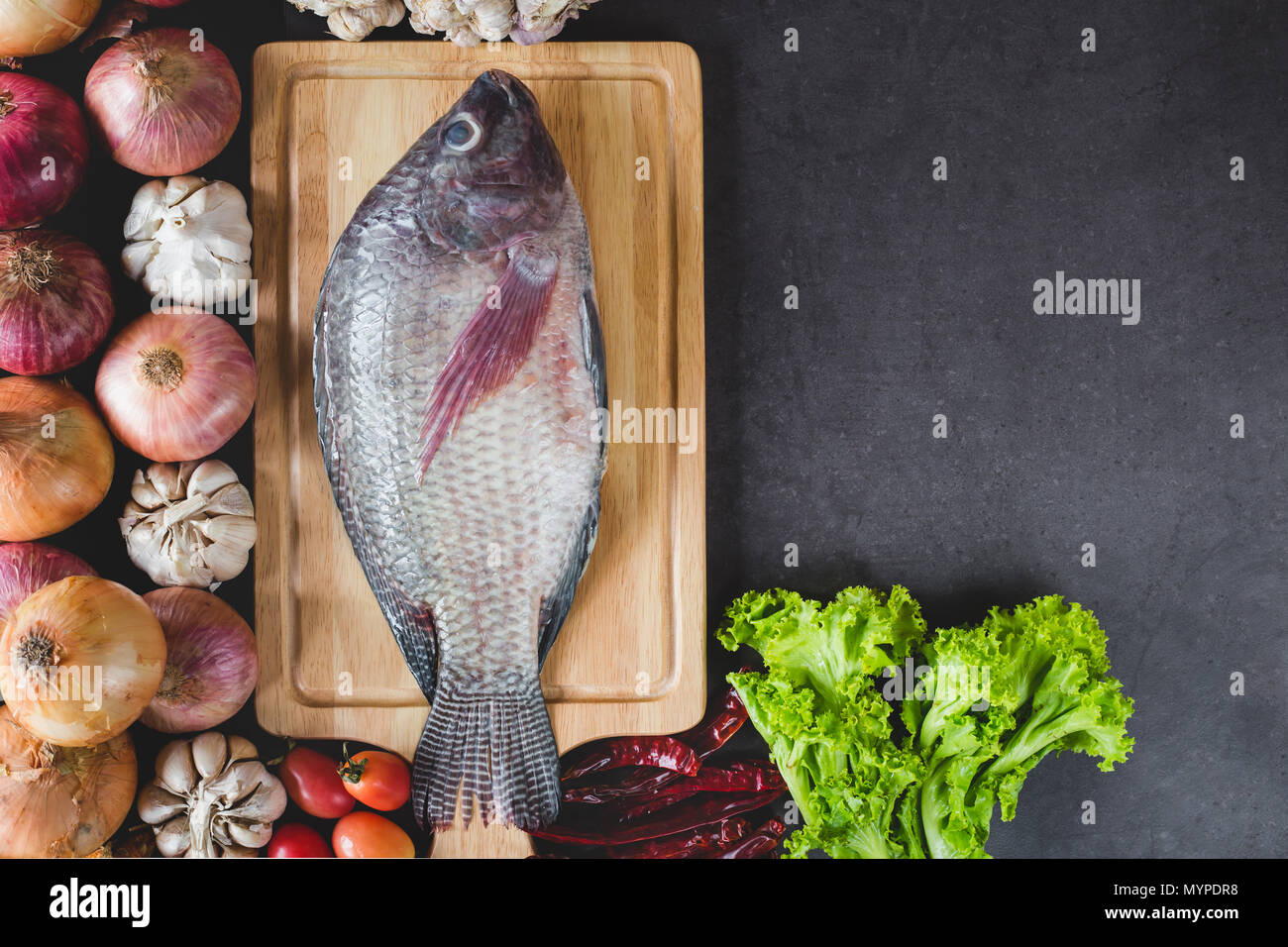 Raw fish cooking and ingredients. herbs and spices. Top view on stone ...