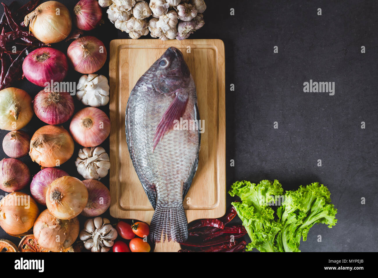 Raw fish cooking and ingredients. herbs and spices. Top view on stone ...