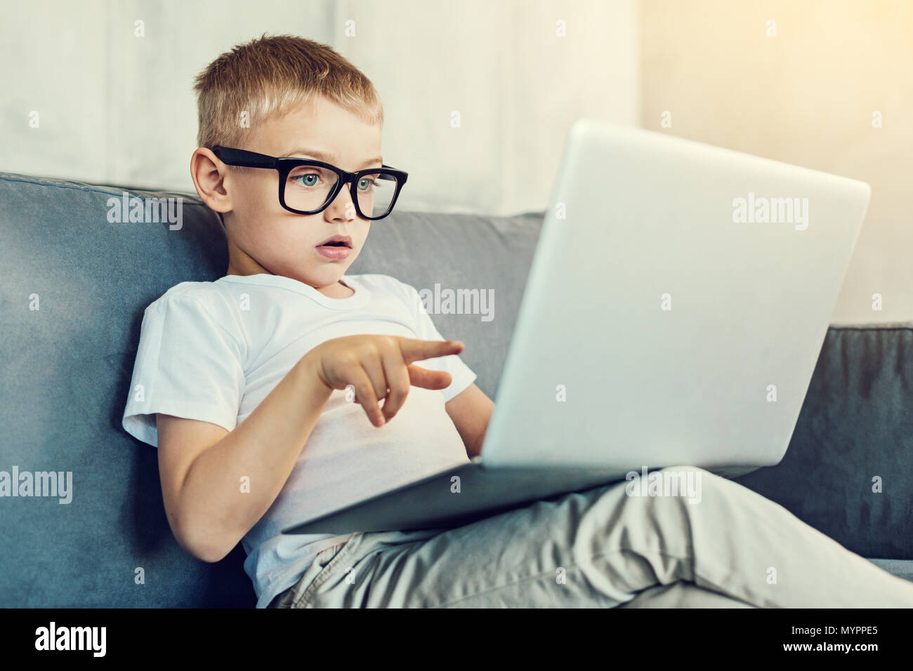 Busy little boy pointing at the screen of his device Stock Photo - Alamy