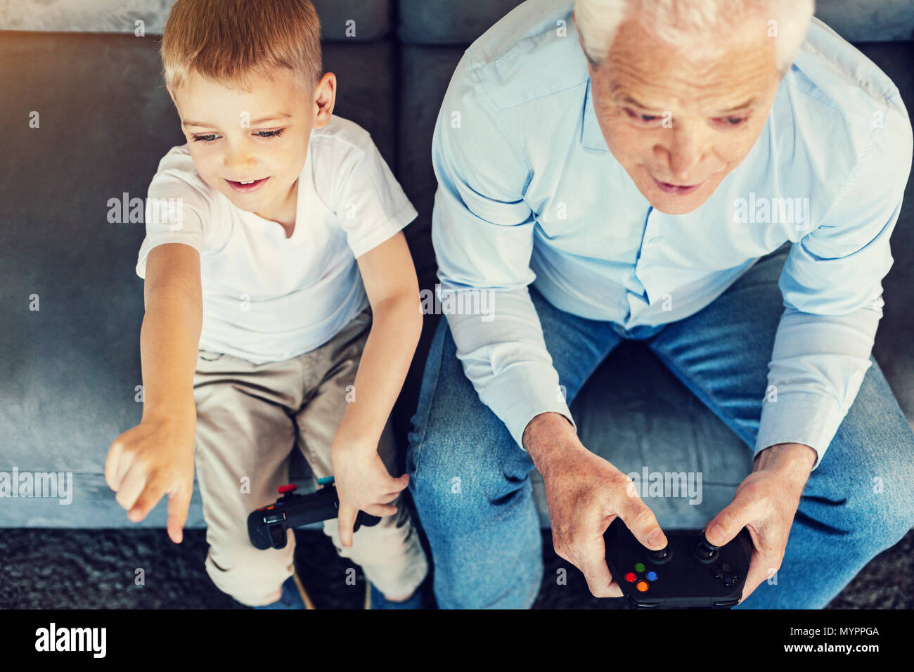 Men of two generations playing games together Stock Photo - Alamy