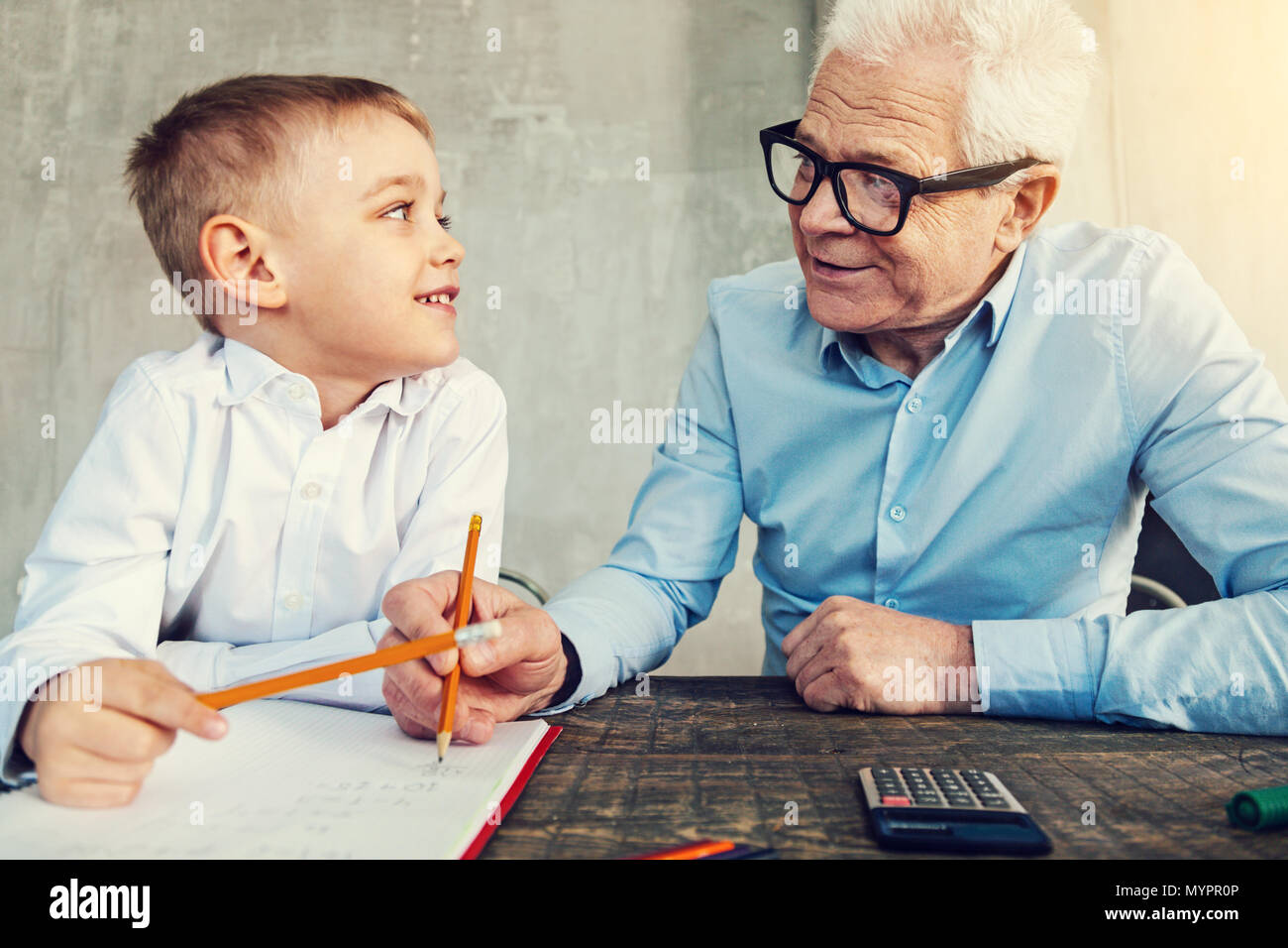 Kind smiling man helping his little grandchild Stock Photo - Alamy