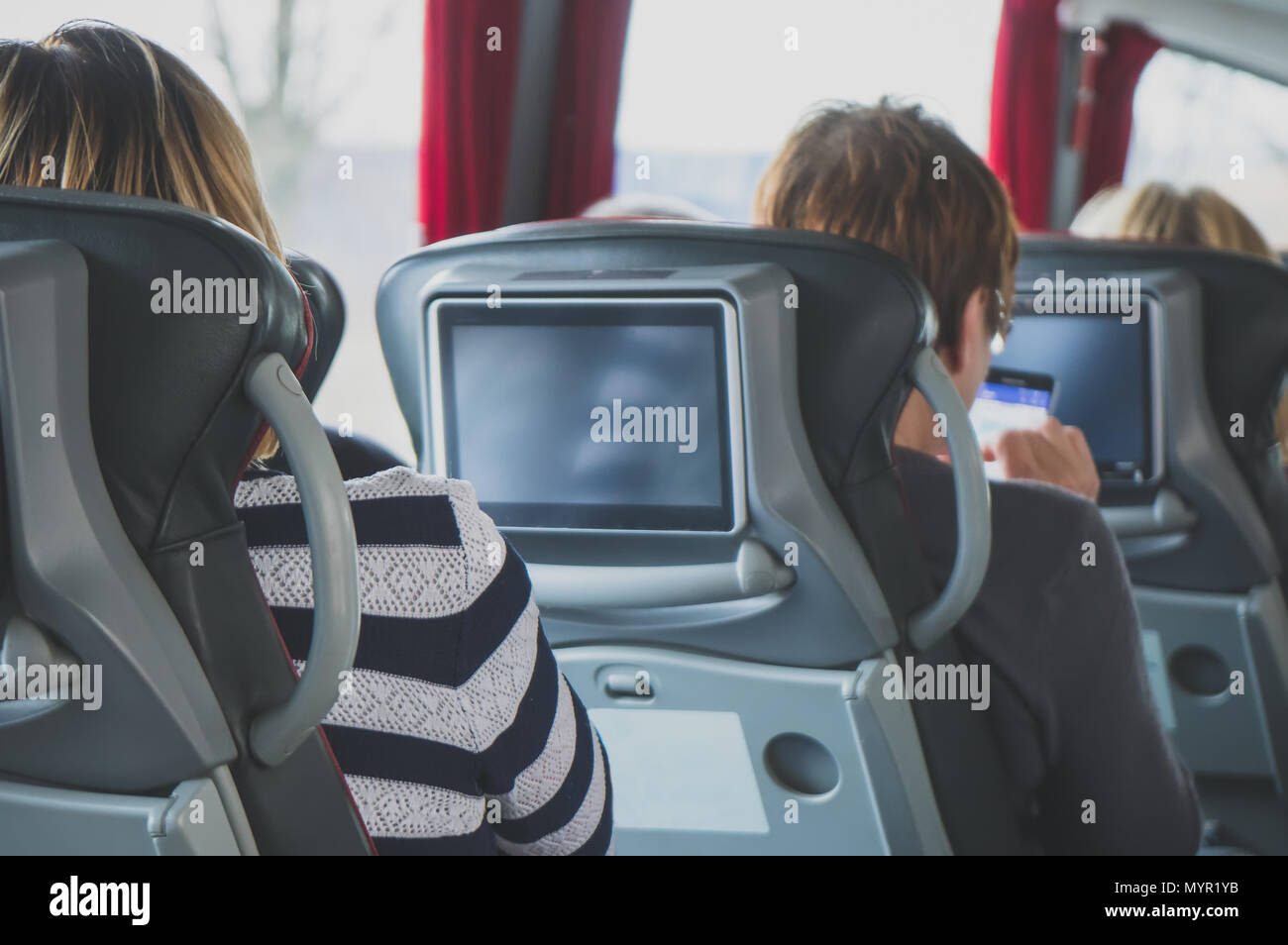 Tourist bus with passengers and built-in LCD tablets Stock Photo - Alamy