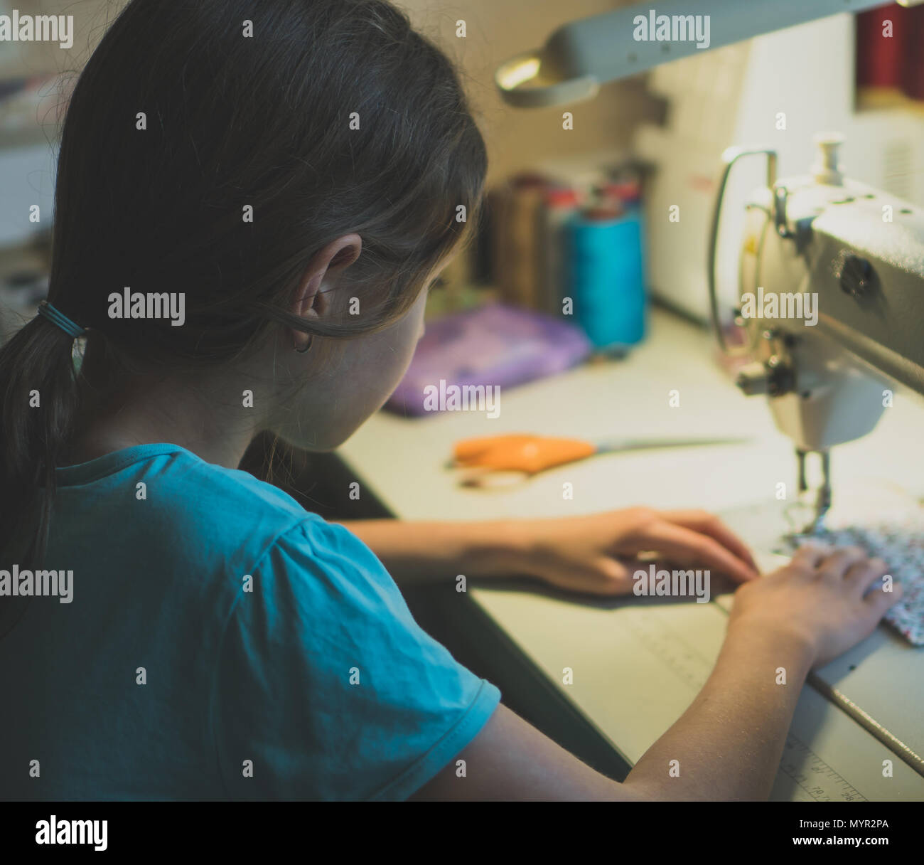 Little girl working on sewing machine at home. Close-up view Stock ...
