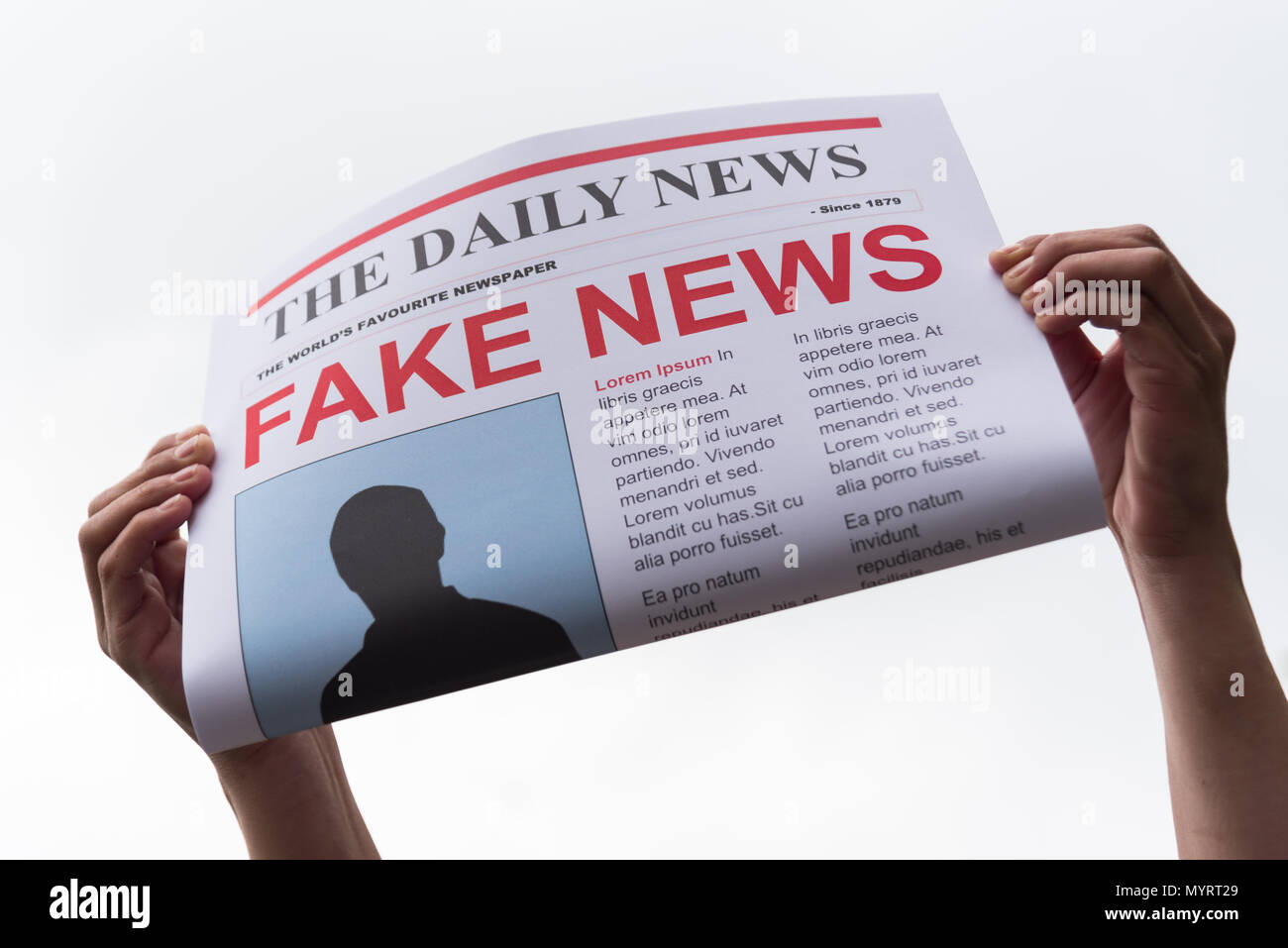Woman holding up a newspaper with the headline fake news Stock Photo ...
