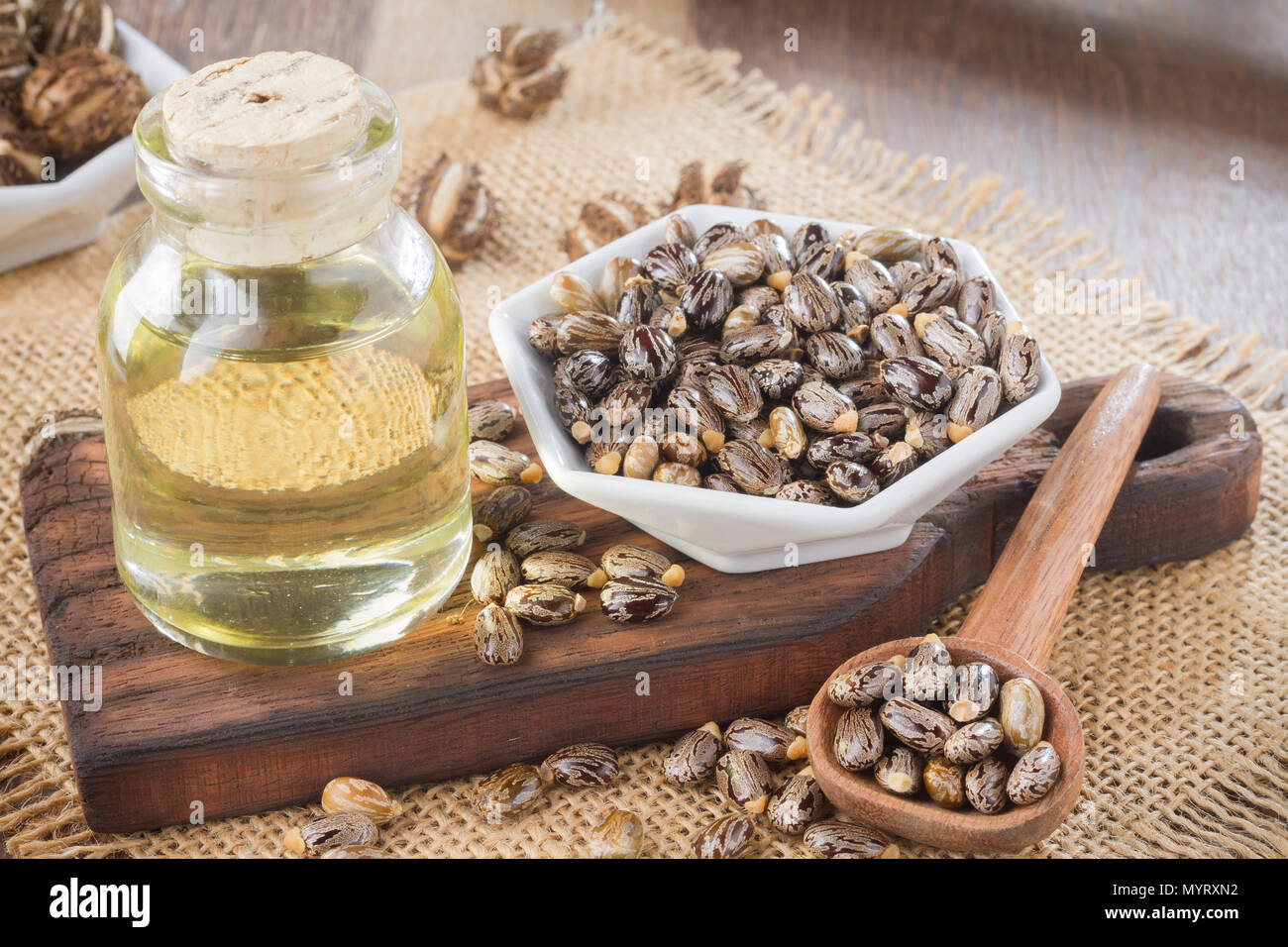 seeds and castor oil on the wooden table - Ricinus communis Stock Photo ...