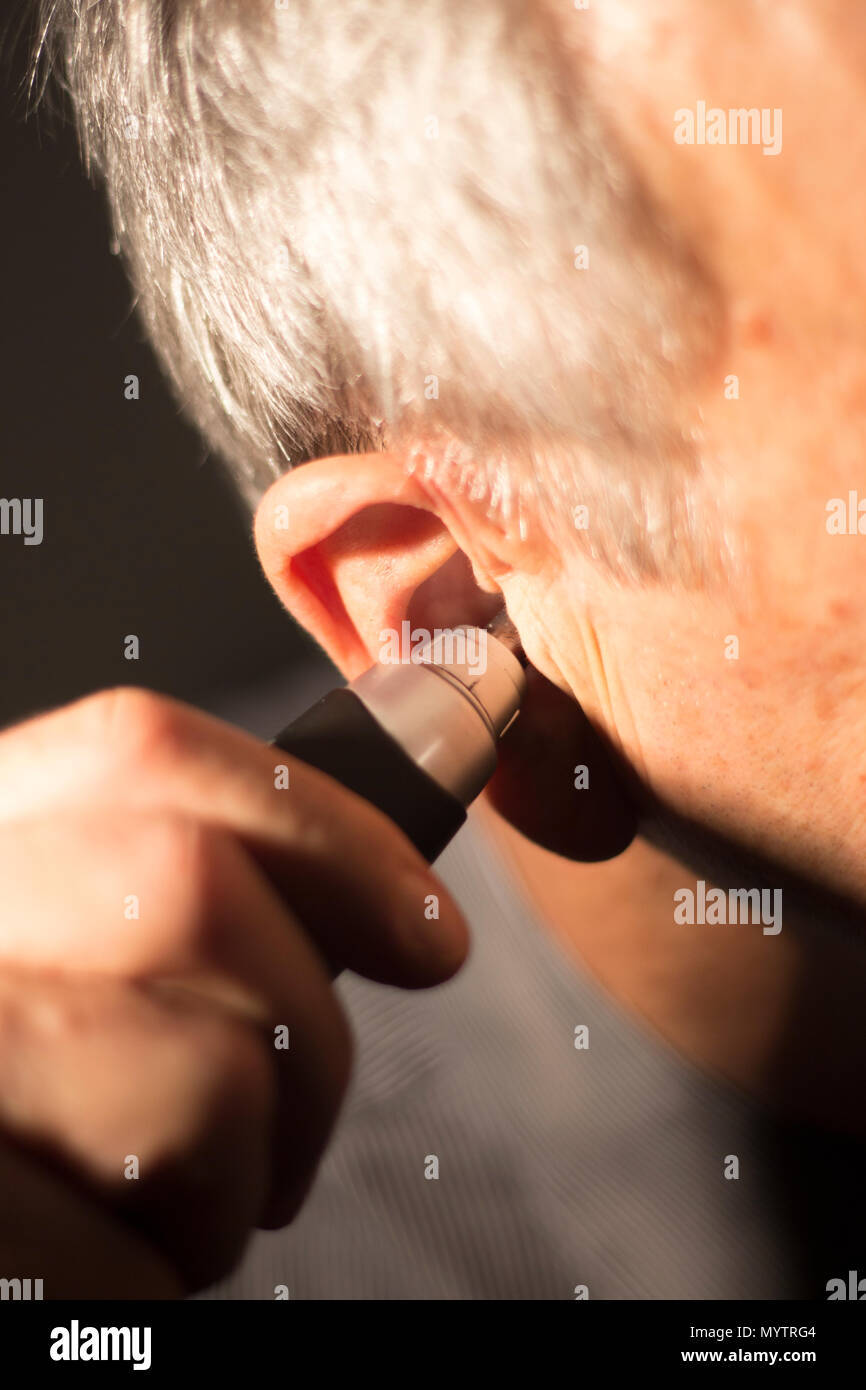 Senior citizen man cutting inner ear hair with electric cutter Stock ...