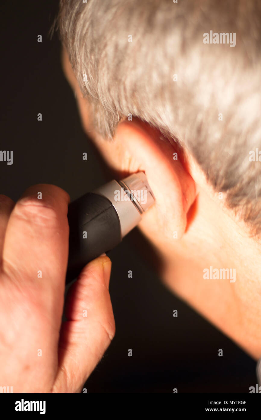 Senior citizen man cutting inner ear hair with electric cutter Stock ...