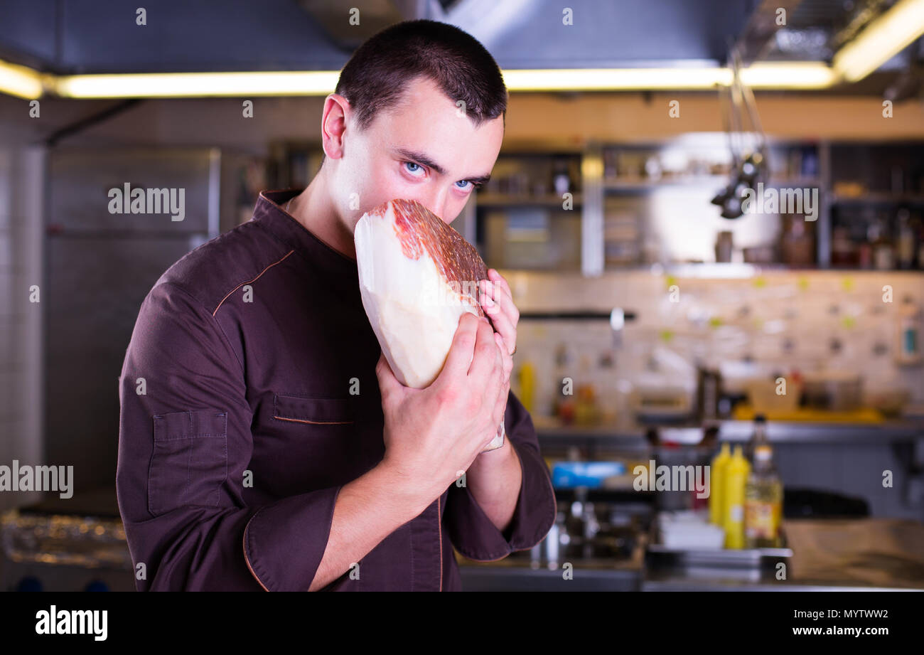 Chef smelling a big piese of raw meat Stock Photo - Alamy