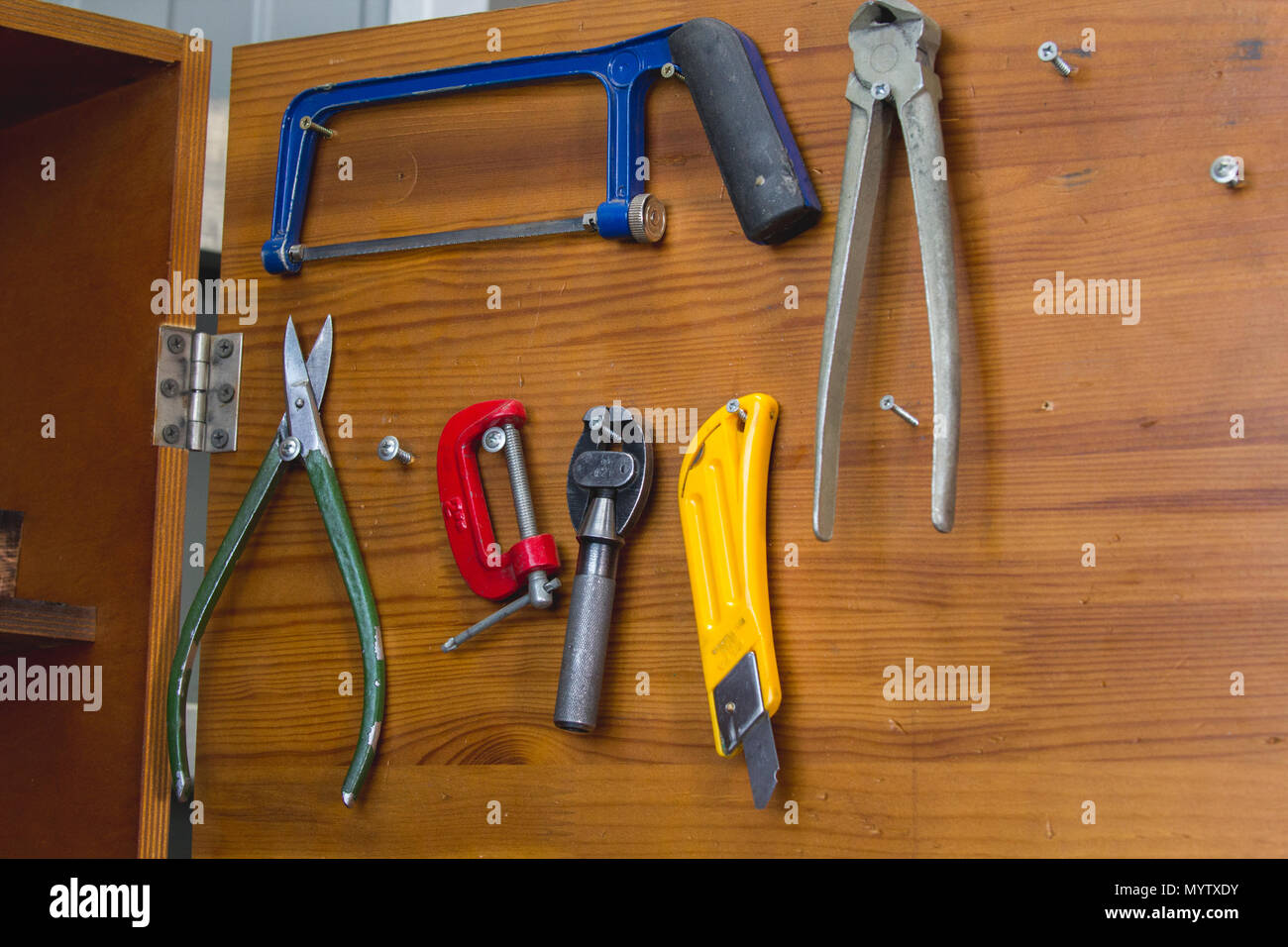 Set of working tools hanging on the shelf Stock Photo - Alamy