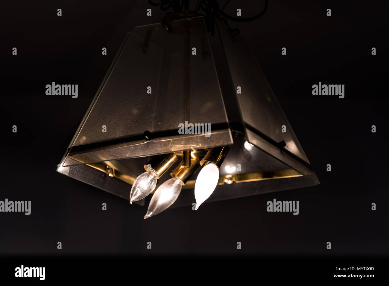 Closeup of old-fashioned light lit modern fixture lamp hanging from ...