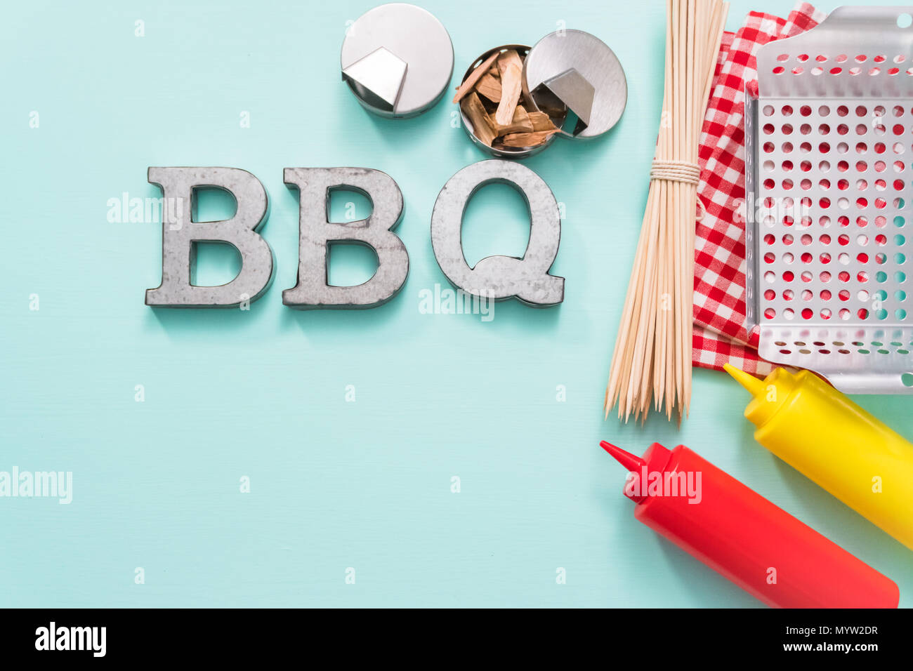 Metal BBQ sign with grilling tools on blue background Stock Photo - Alamy