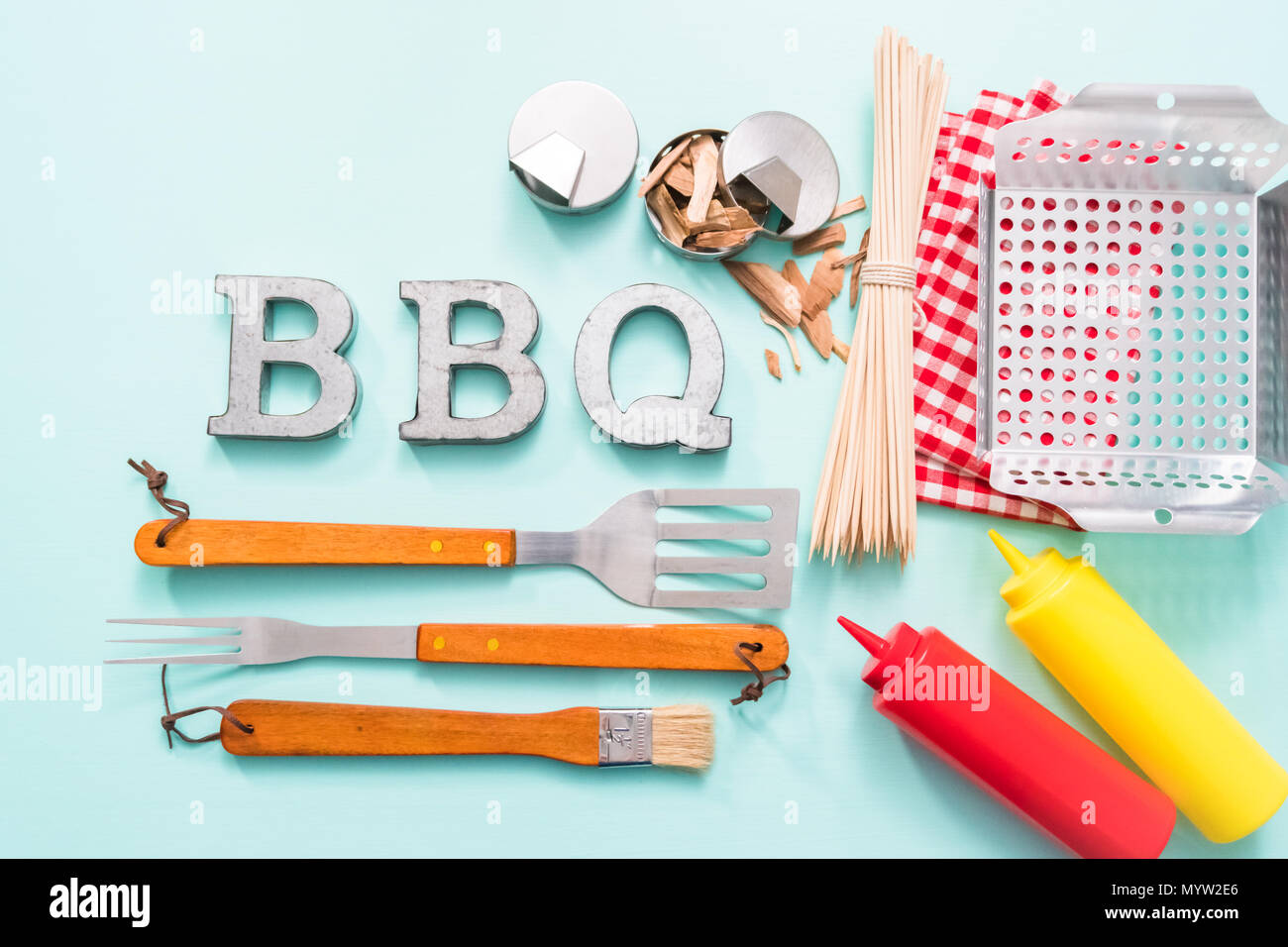 Metal BBQ sign with grilling tools on blue background Stock Photo - Alamy