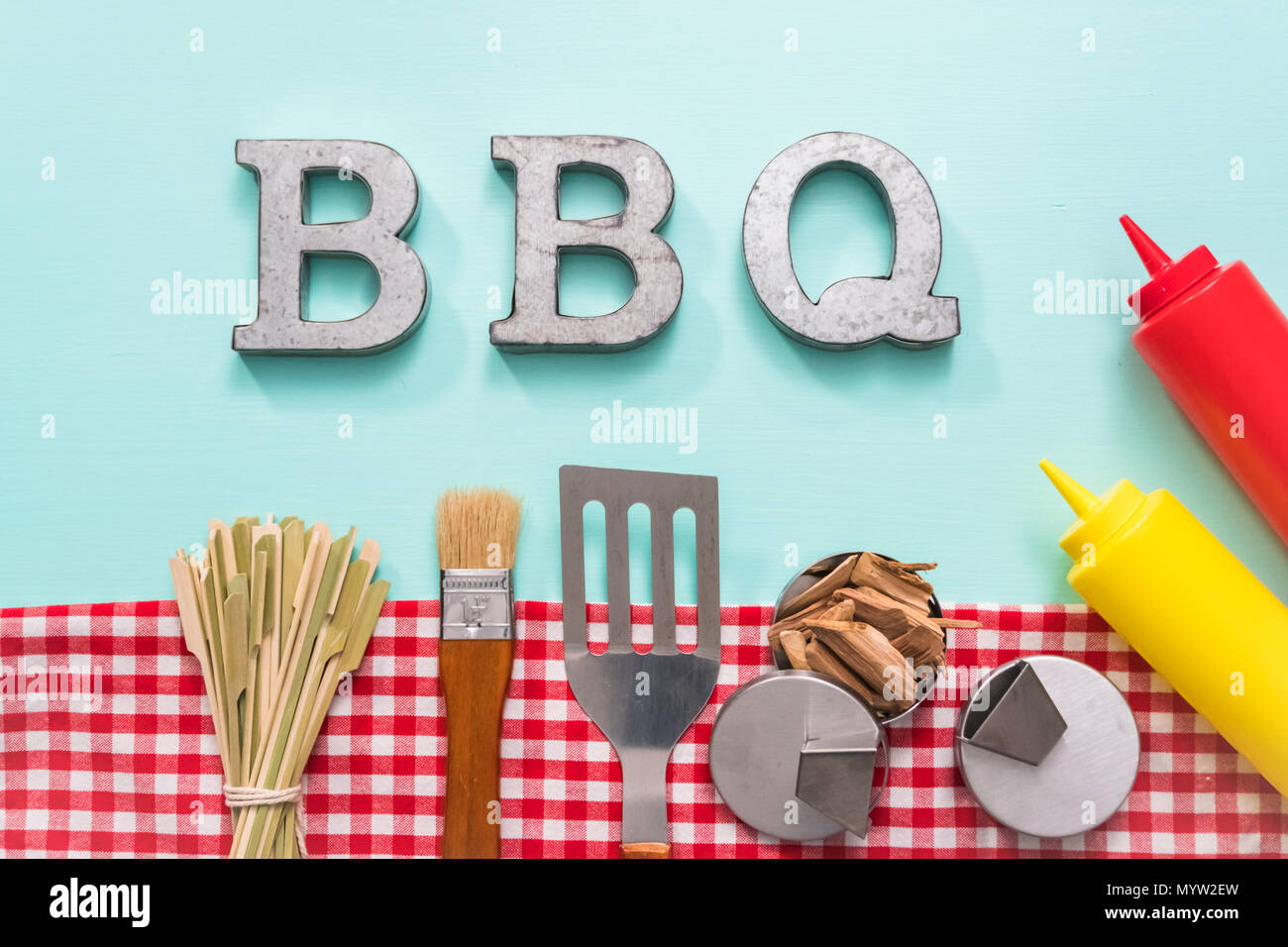 Metal BBQ sign with grilling tools on blue background Stock Photo - Alamy