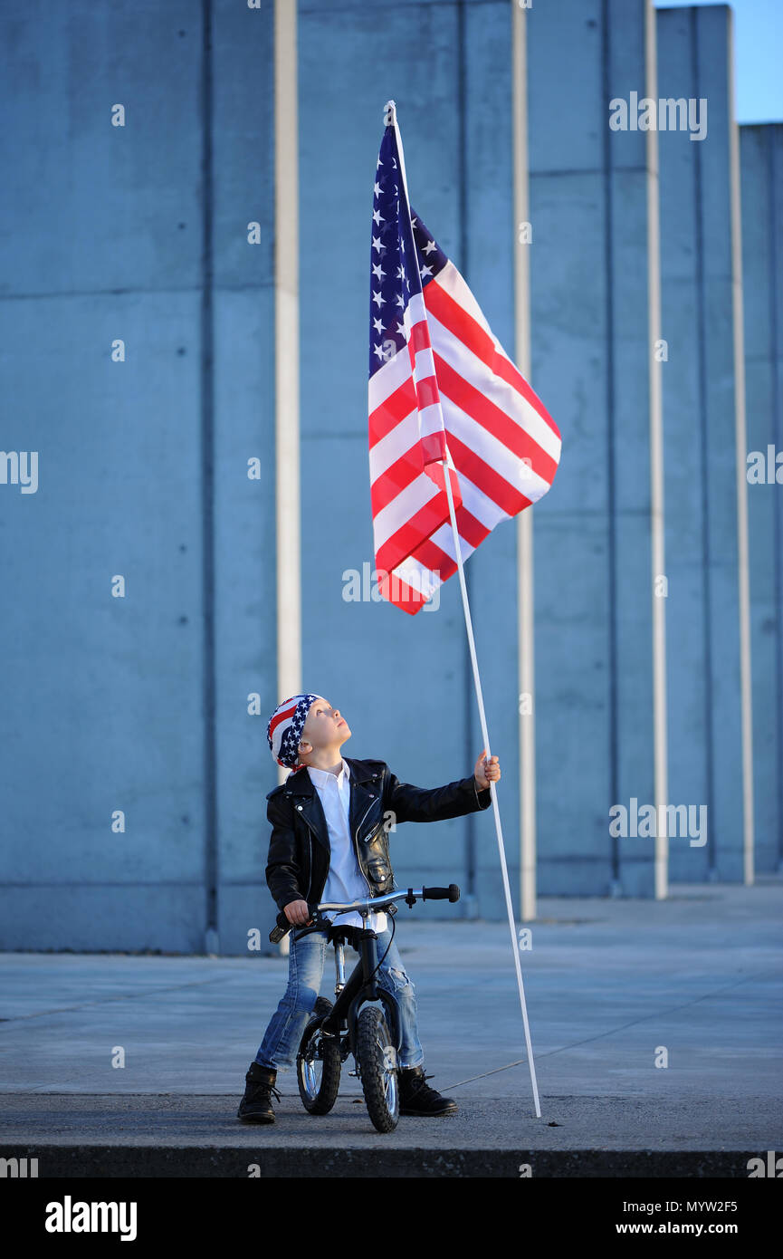 Happy handsome boy smiling and waving American flag outside, wearing ...