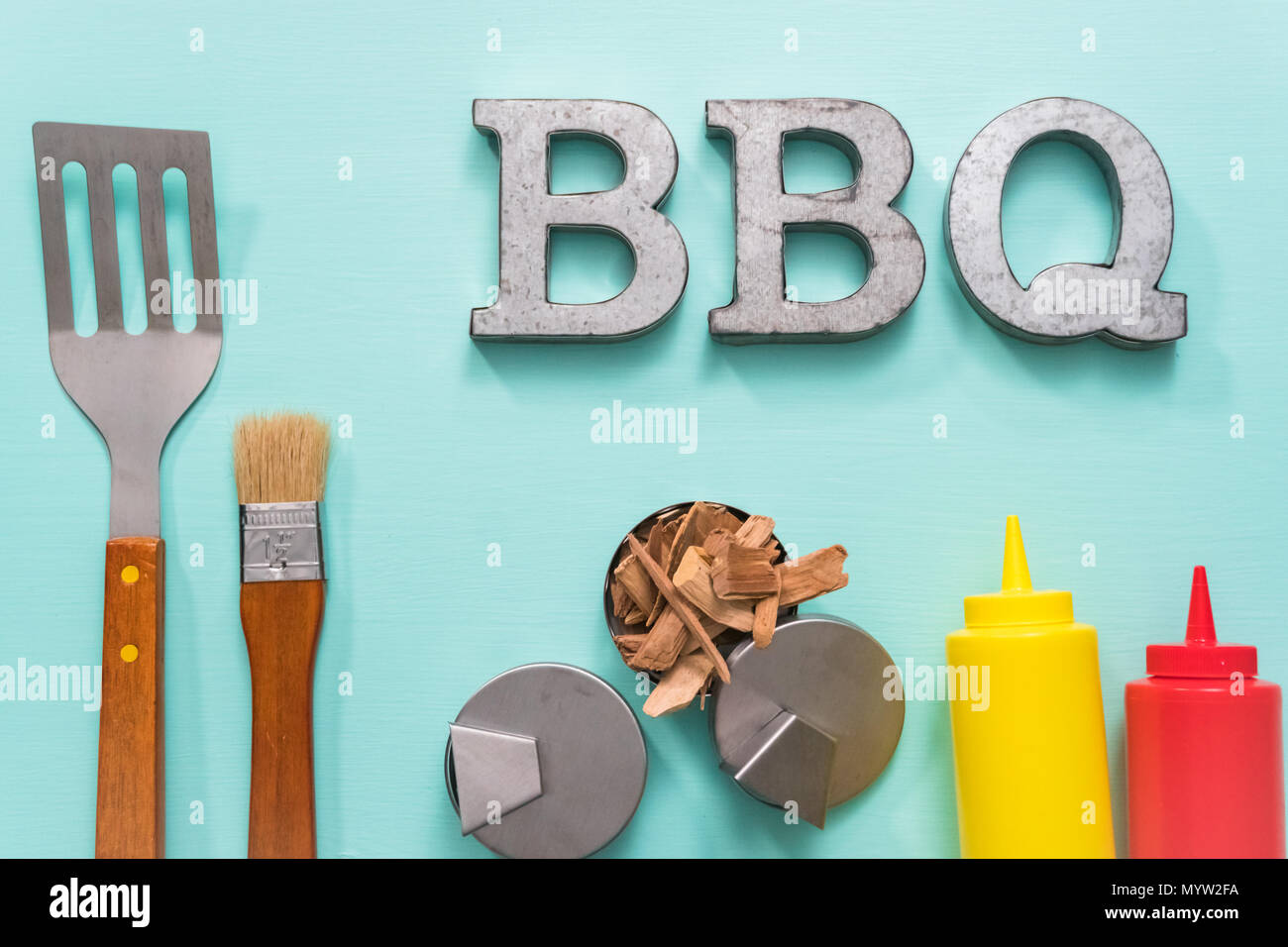 Metal BBQ sign with grilling tools on blue background Stock Photo - Alamy