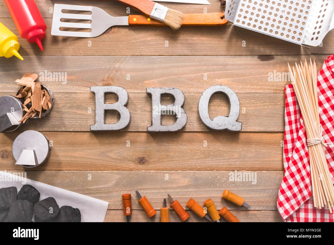 Metal BBQ sign with grilling tools on wood background Stock Photo - Alamy