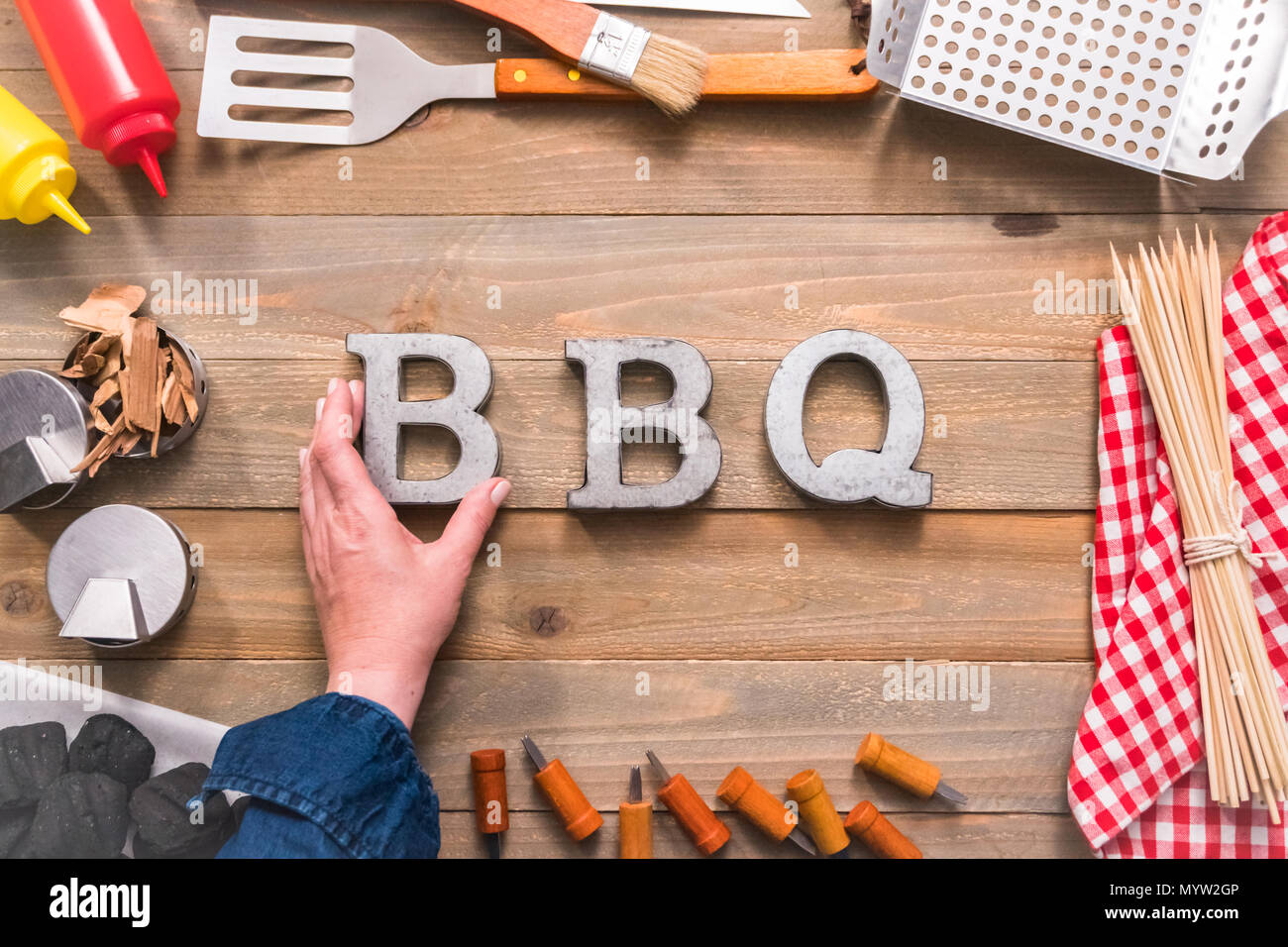 Metal BBQ sign with grilling tools on wood background Stock Photo - Alamy
