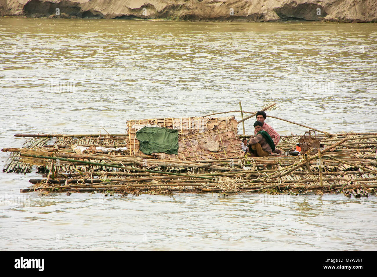 Local men floating on a bamboo raft down Ayeyarwady river near Mandalay ...