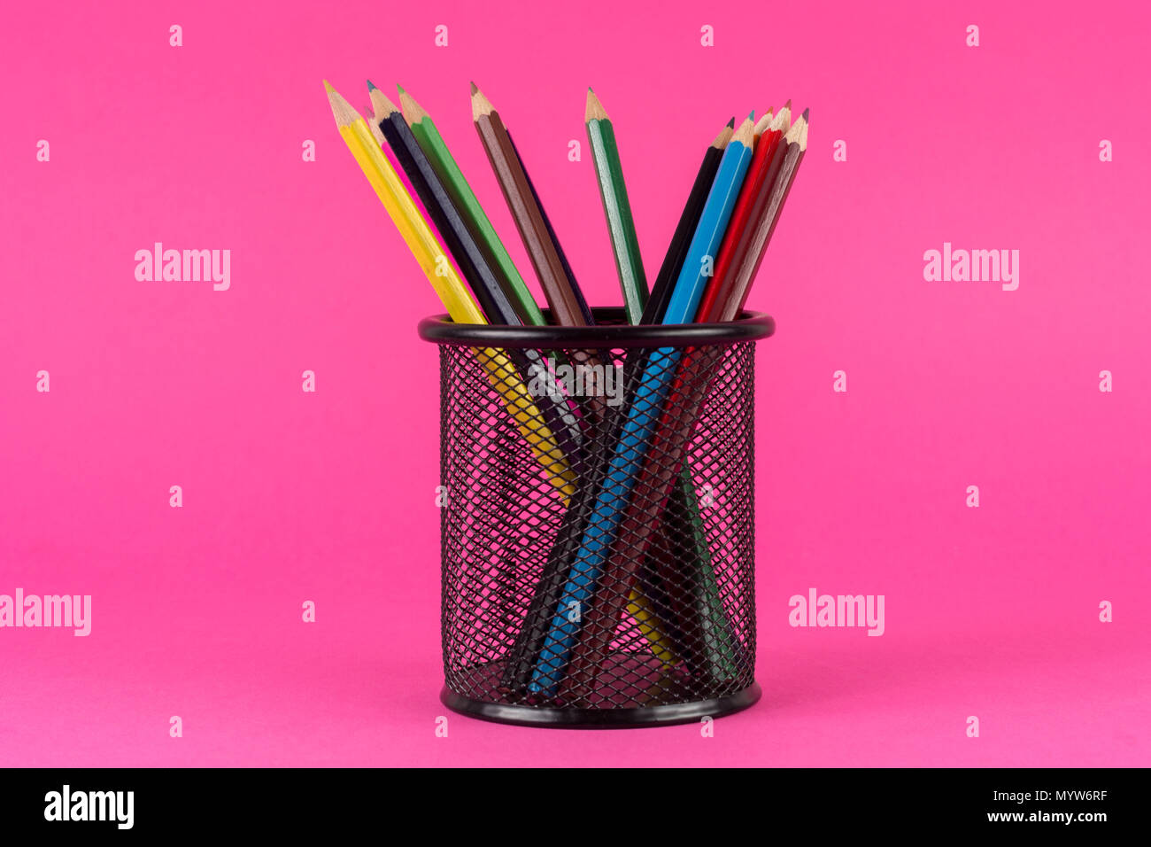 Various of colored pencils in metal basket isolated on pink background ...